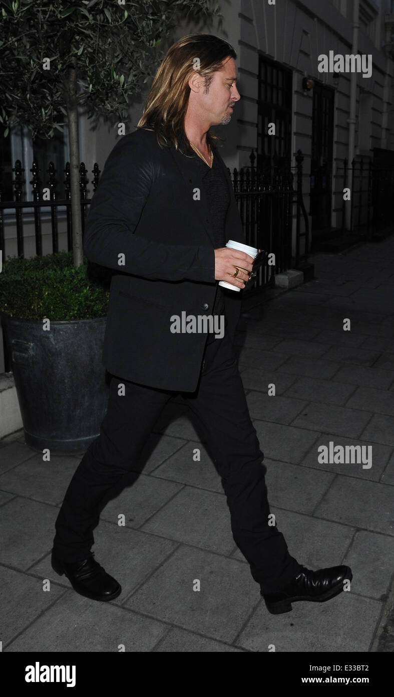 Brad Pitt, holding a cup of coffee, leaves a private residence to go ...