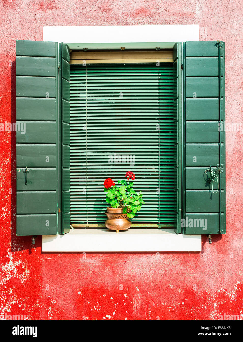 Green venetian windows with flowers. Red wall Stock Photo - Alamy
