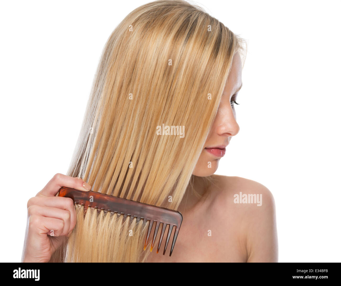 Young woman combing hair Stock Photo - Alamy