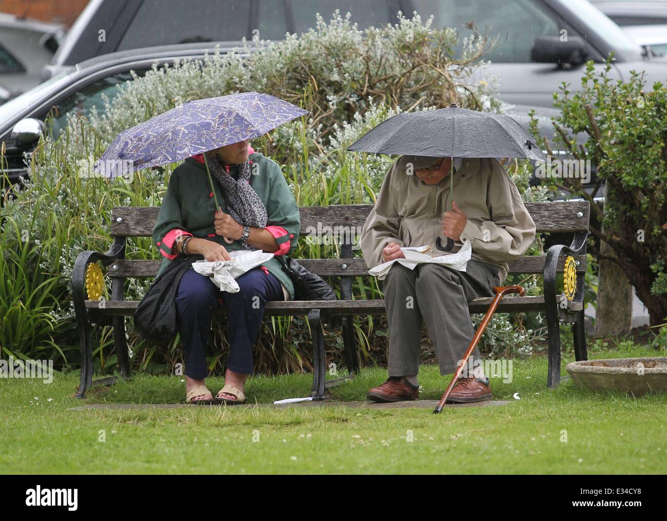 Wet weather pictures form Beaconsfield, Bucks. People sit on benches ...