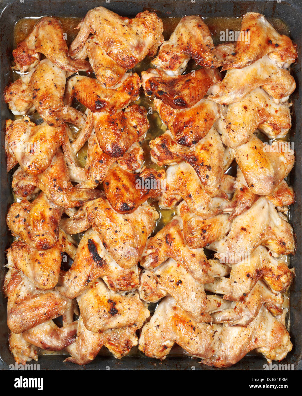 many roasted spicy chicken wings on hot tray Stock Photo - Alamy