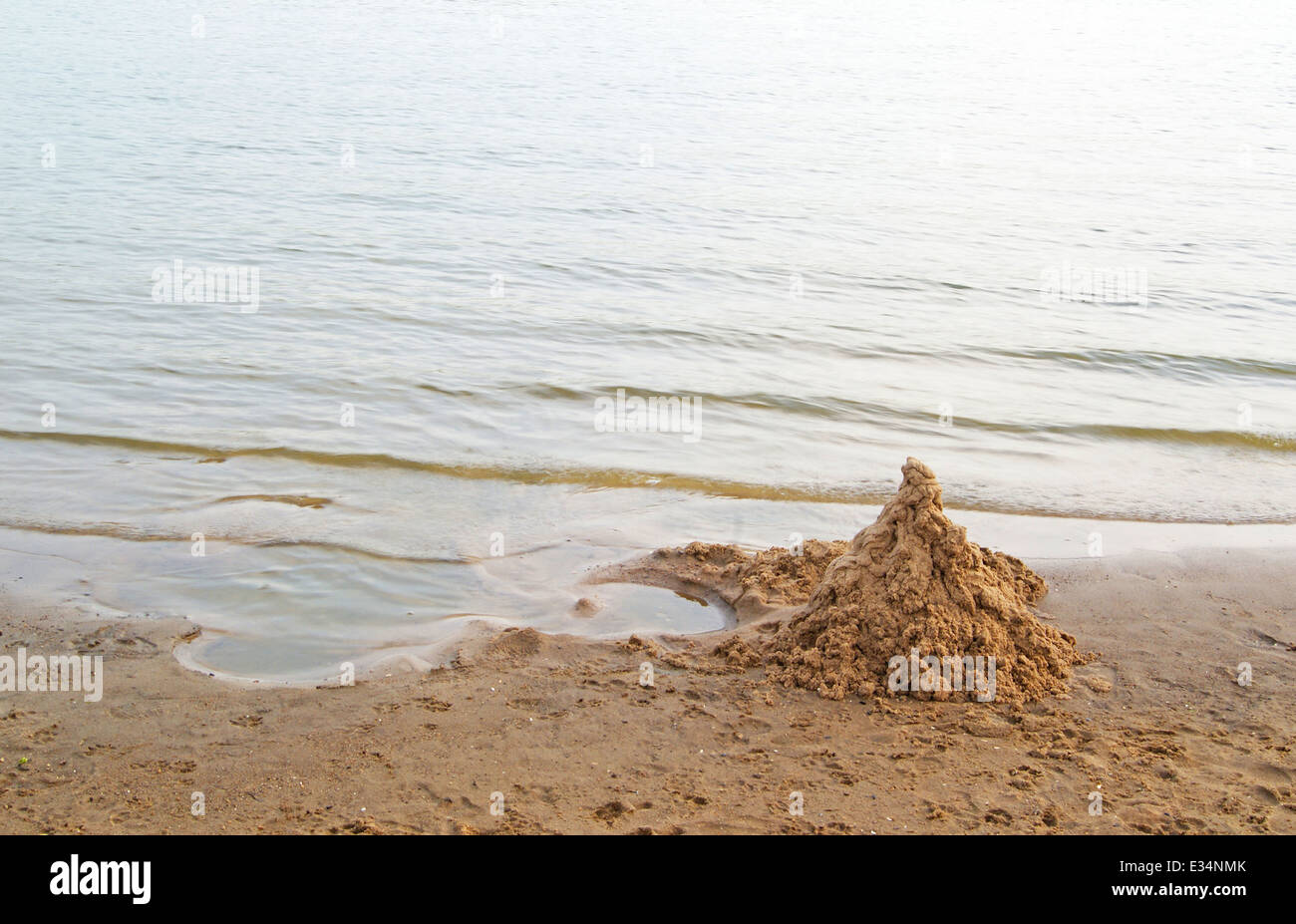 Heap of clean sand shaped as a castle on sea beach Stock Photo - Alamy