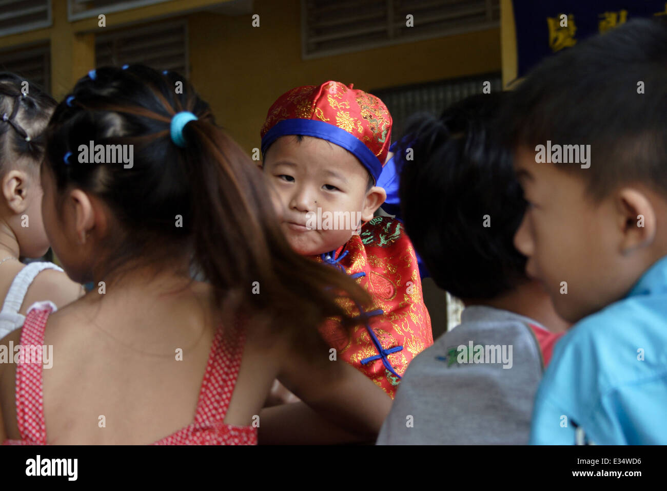 A 9 year old boy wearing a Chinese costume has a serious look at the ...