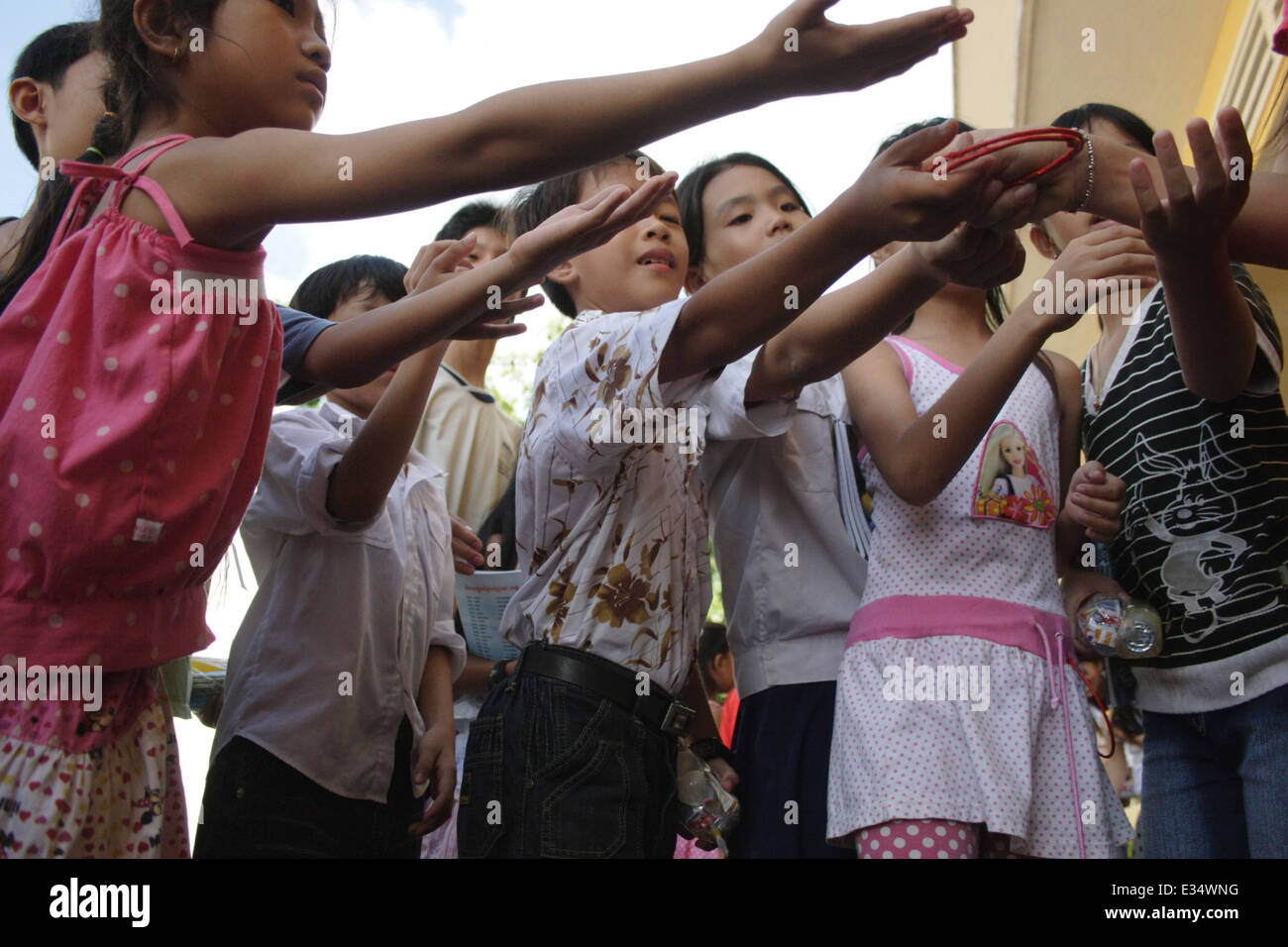 Children are reaching with their hands in order to receive toys at an ...
