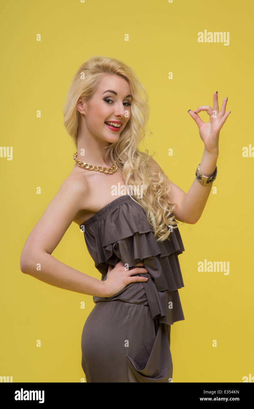 Woman standing on yellow background Stock Photo - Alamy