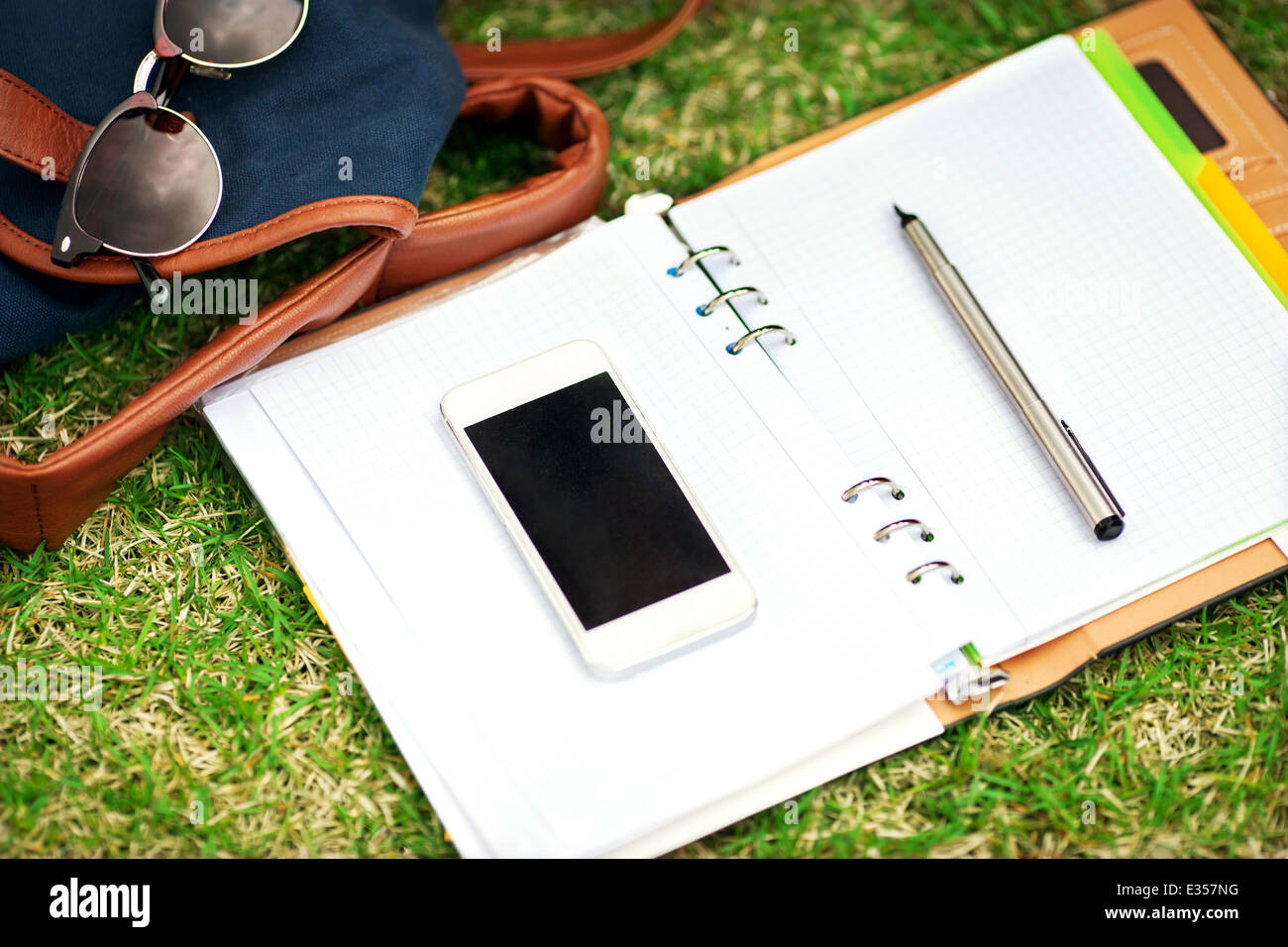 Modern digital notebook with mobile smartphone on green grass Stock ...