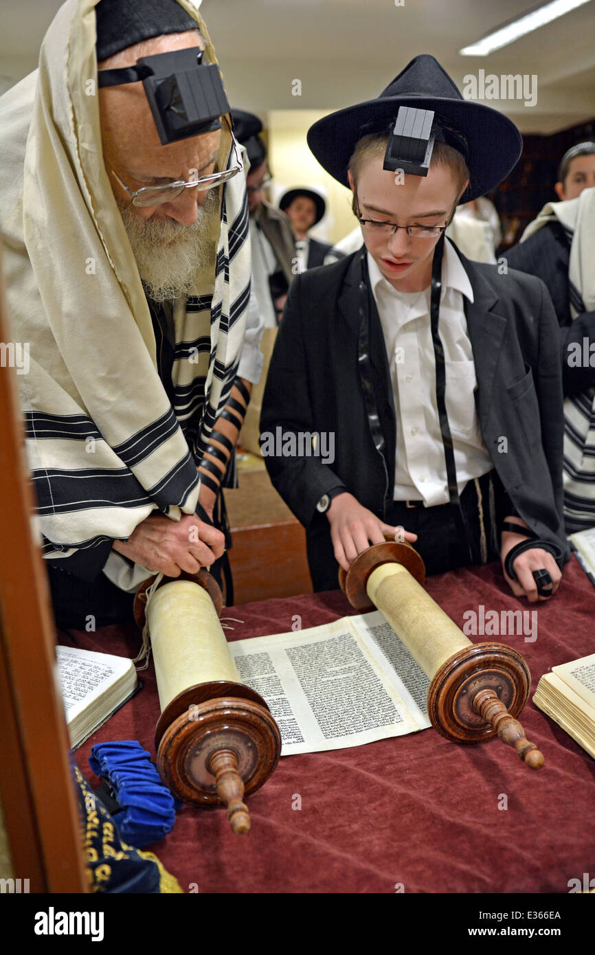 A young boy reading from a Torah scroll at morning services at ...