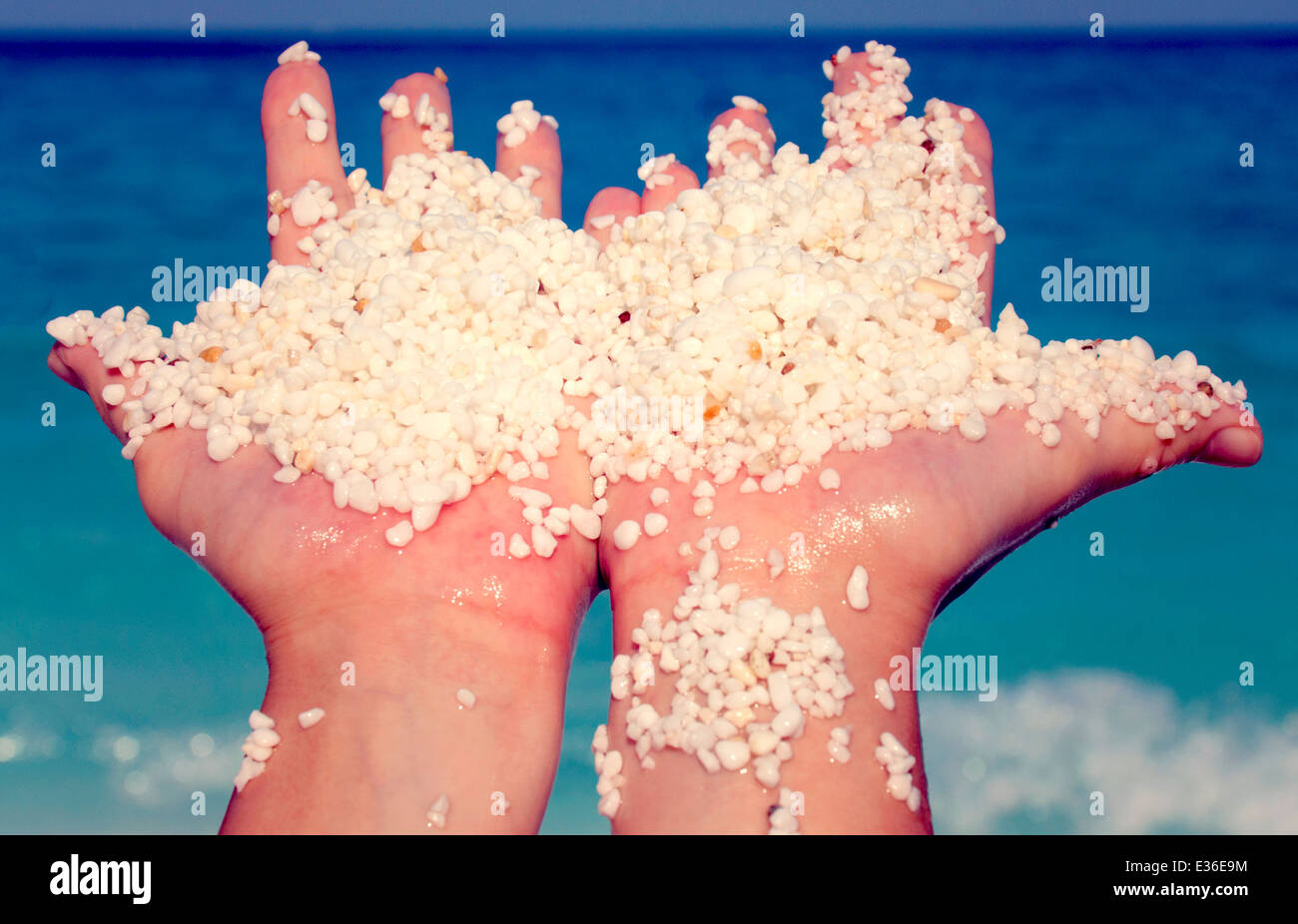 Female hands full of white small stones at the beach Stock Photo - Alamy
