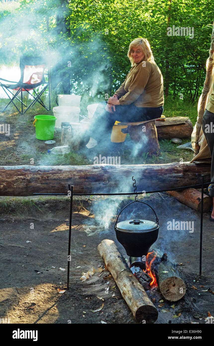 Cooking food by tourists on a fire in the wood. Cook in a kettle Stock ...