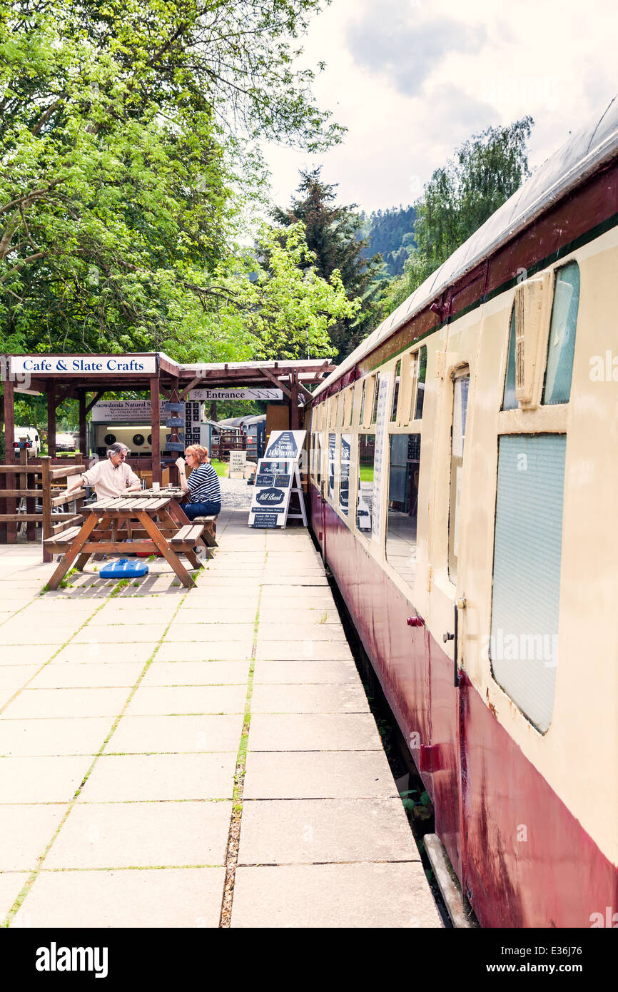 Middle aged couple drinking mugs of tea outside the buffet coach café ...