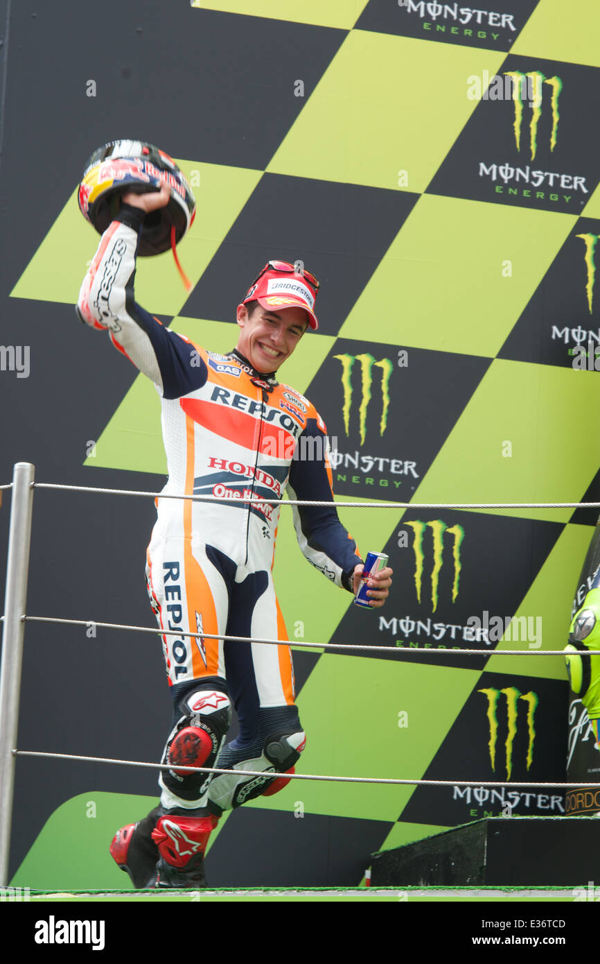 Marc Marques lifts his helmet in celebration as he takes to the podium ...