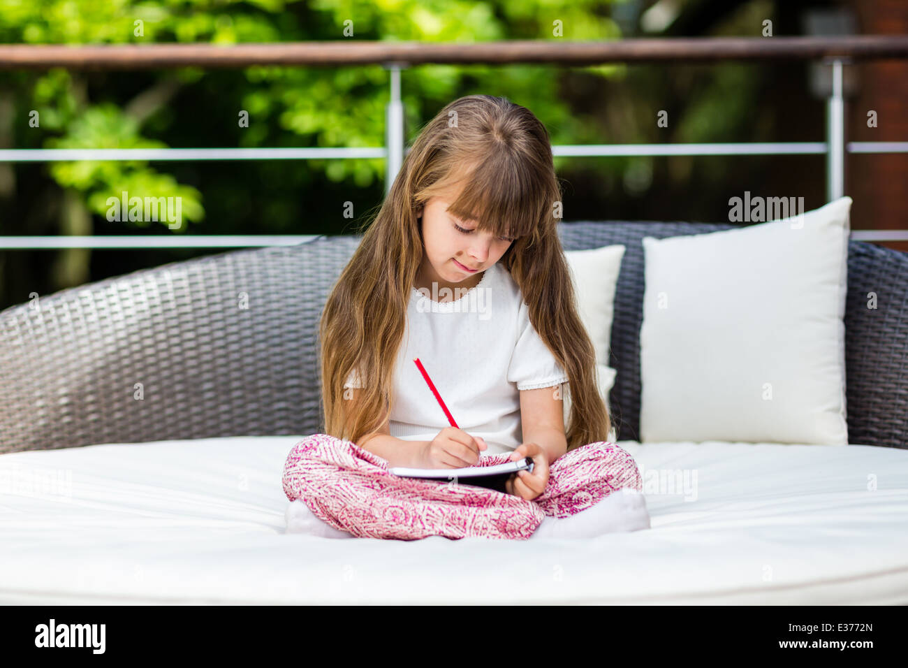 Young caucasian girl sitting on patio and writing on her notepad Stock ...