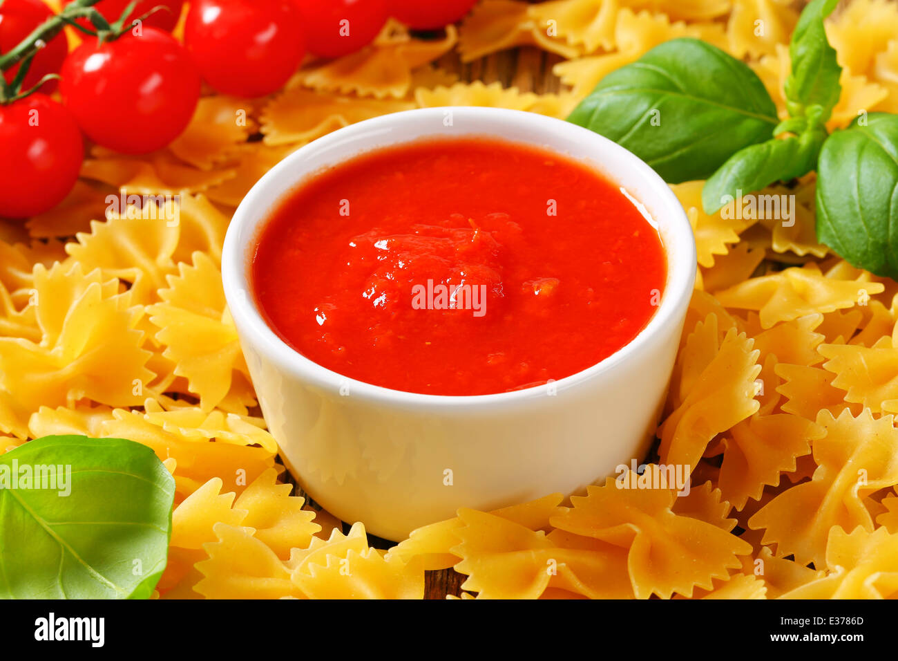 Uncooked bow tie pasta and tomato puree Stock Photo - Alamy