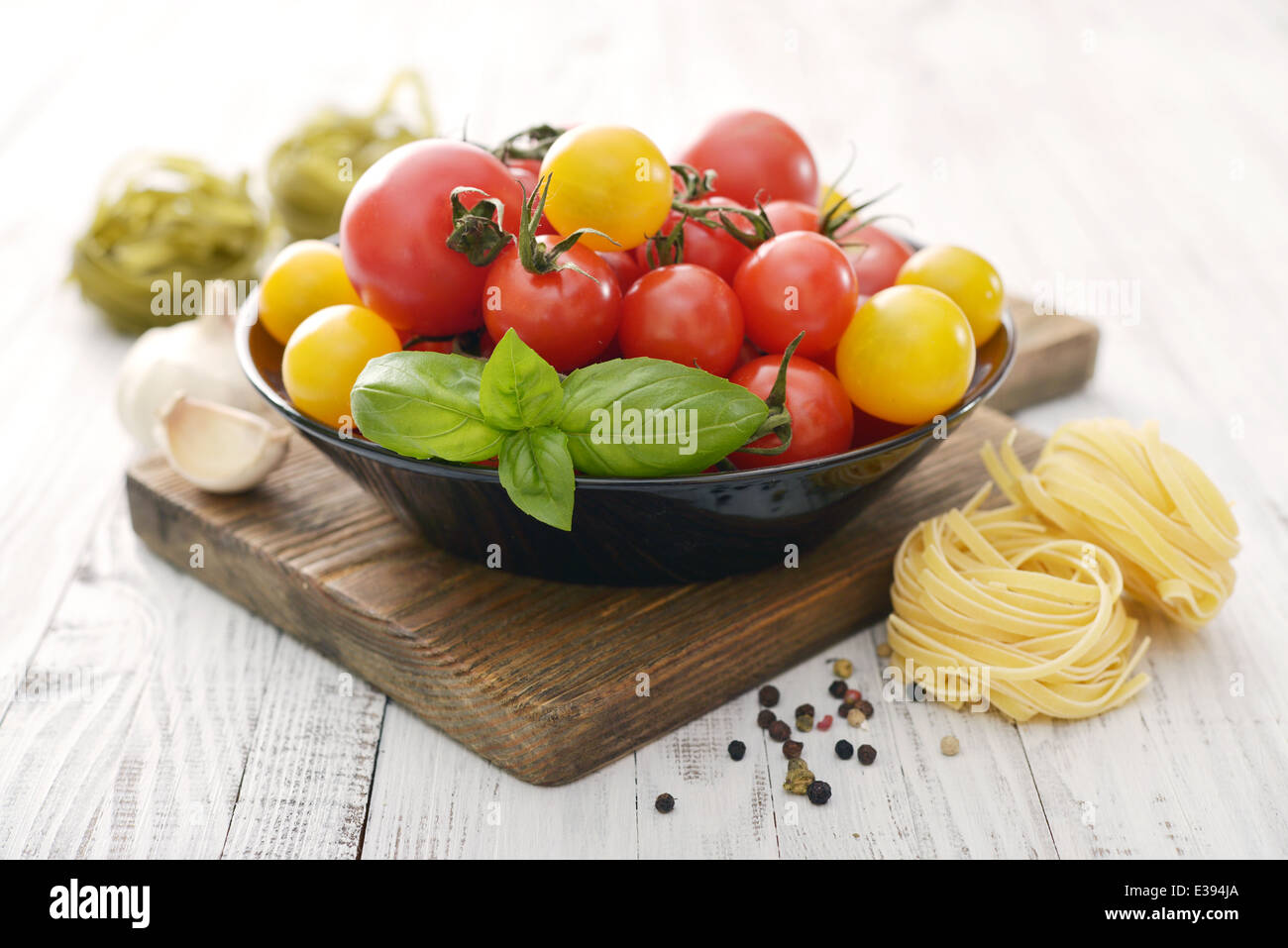 Fresh ripe tomato on plate and basil on wooden background Stock Photo ...