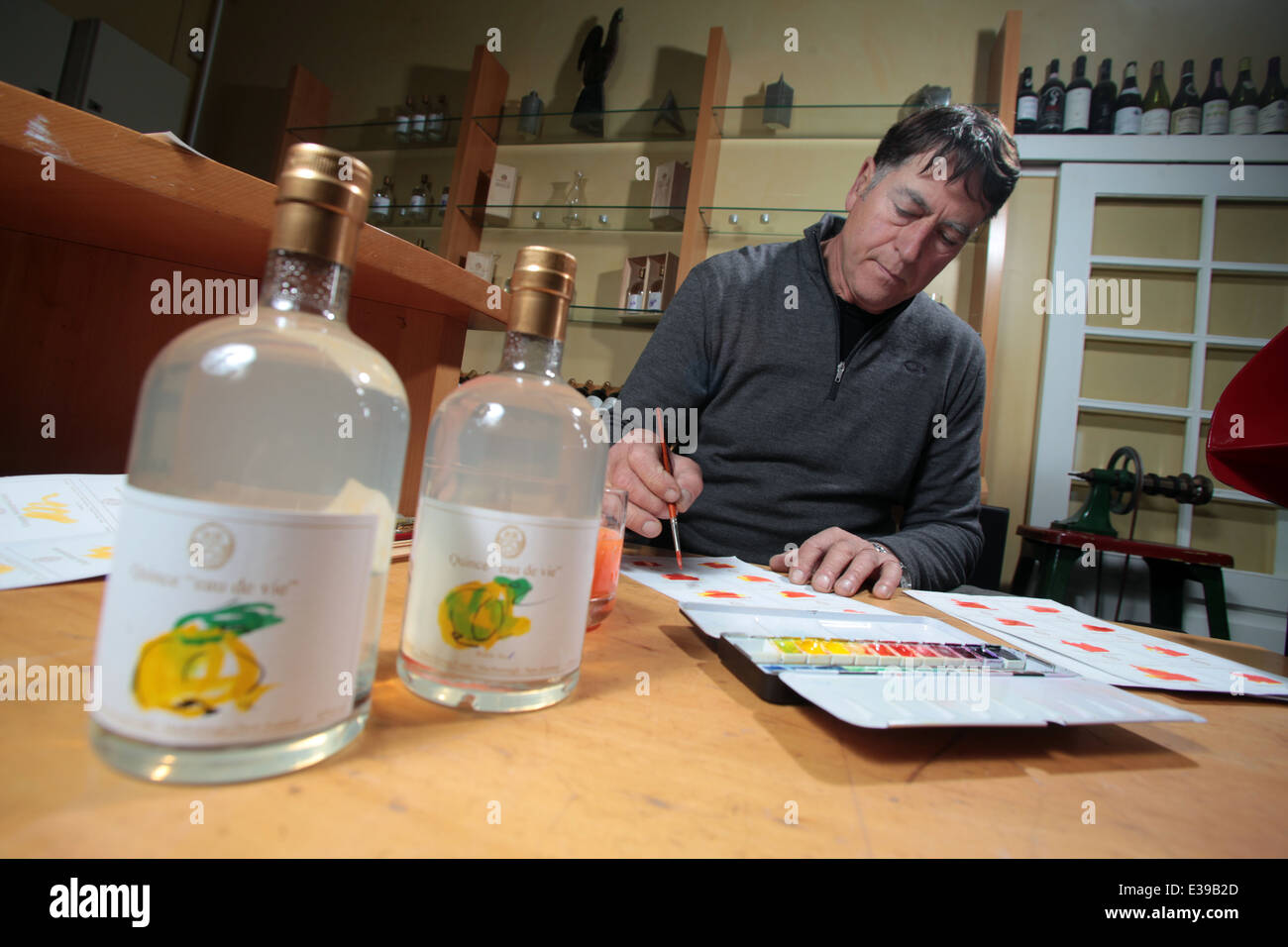 Hans Herzog hand painting his labels for schnapps produced at his ...