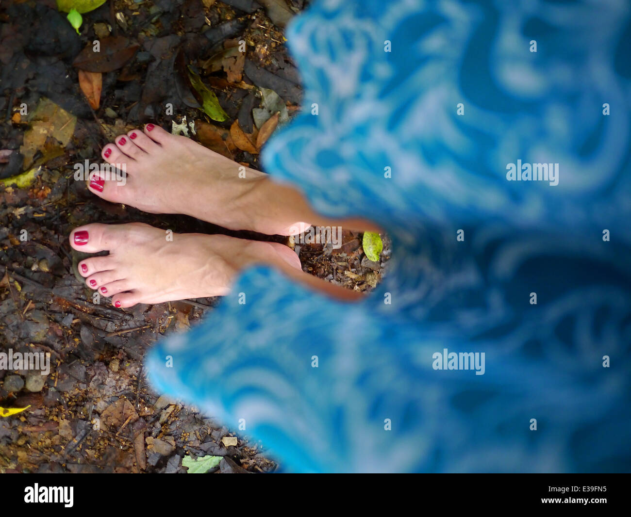 Woman wearing a blue dress walking barefoot on the jungle Stock Photo ...