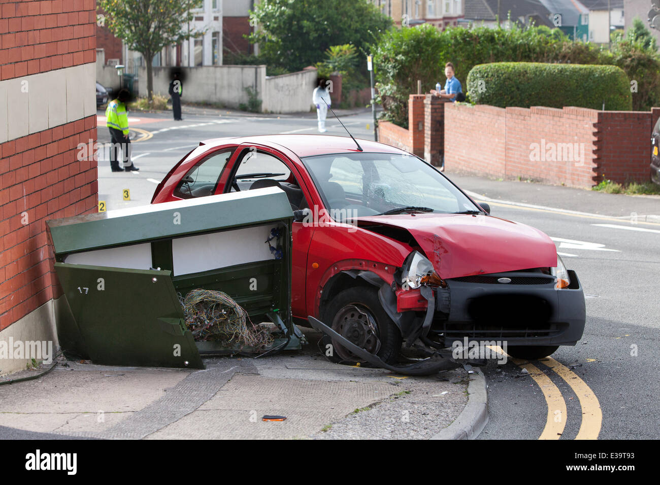 A red Ford KA can be seen crashed into a telecoms cabinet and three ...