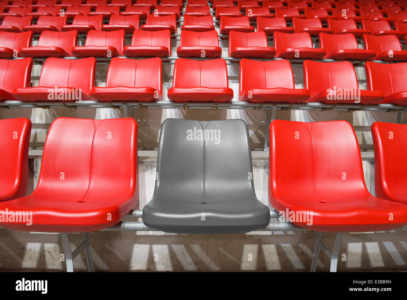 grey stadium seat between red seats Stock Photo - Alamy