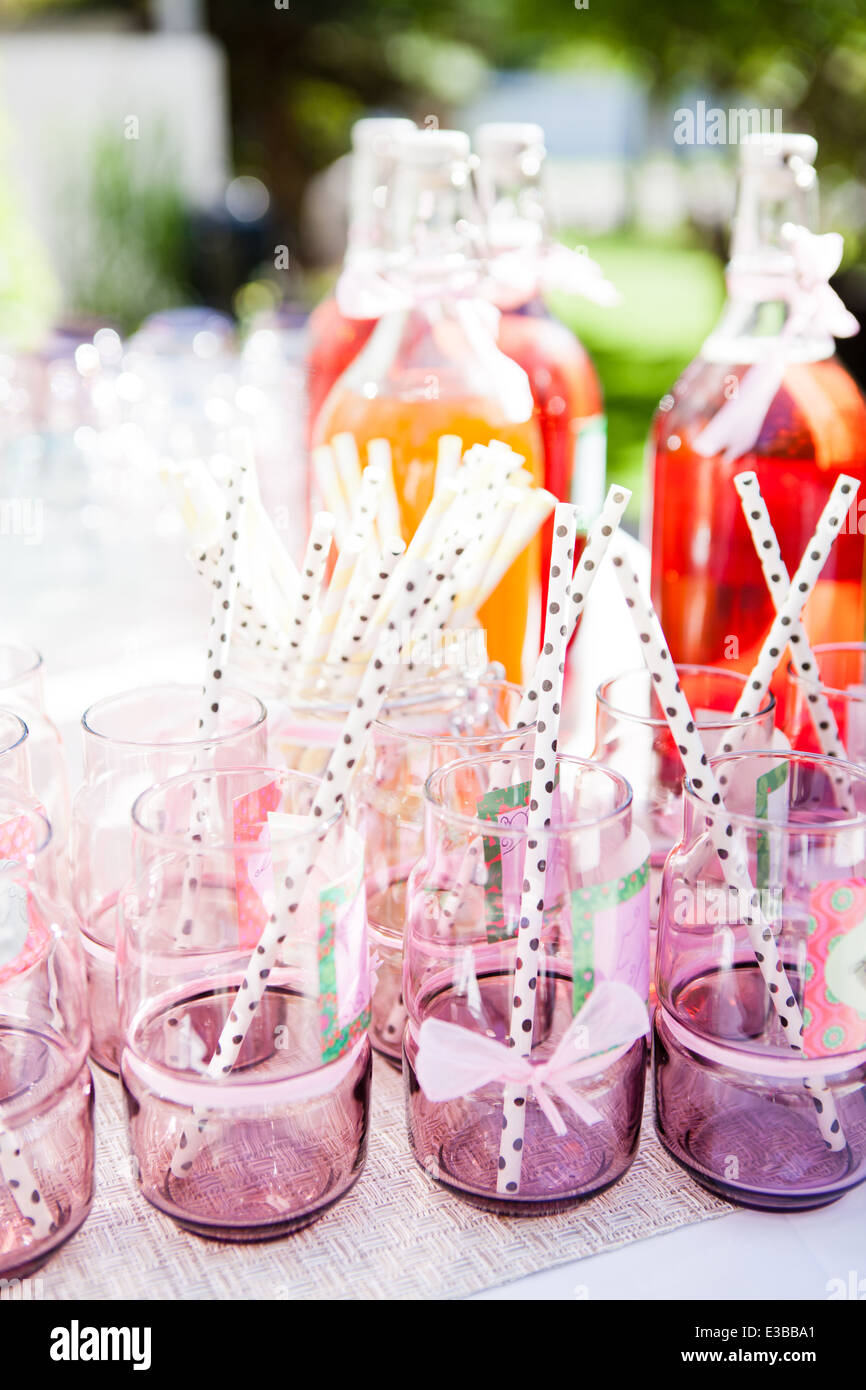 Closeup of decorative pink colored party glasses with straws on table ...