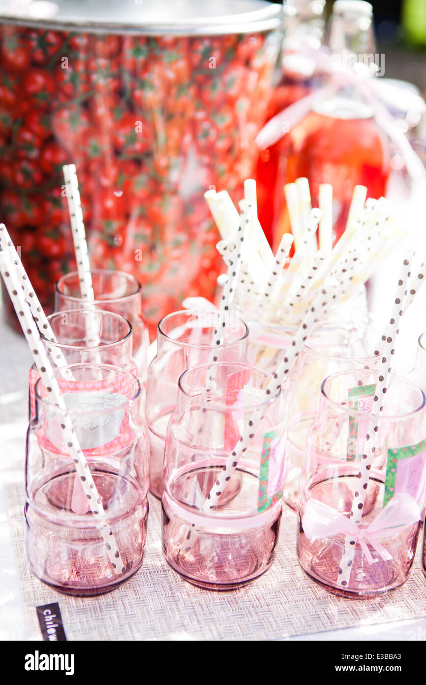 Closeup of decorative pink colored party glasses with straws on table ...