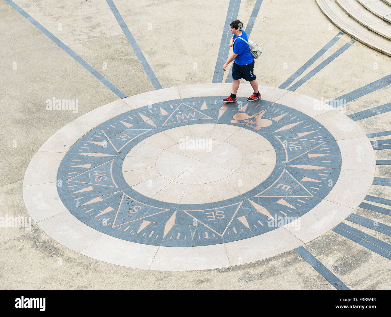 A young boy walking over a large stylised compass Stock Photo - Alamy
