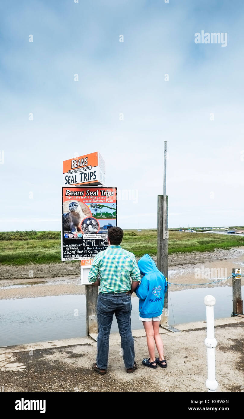 Tourists looking at a poster Stock Photo - Alamy