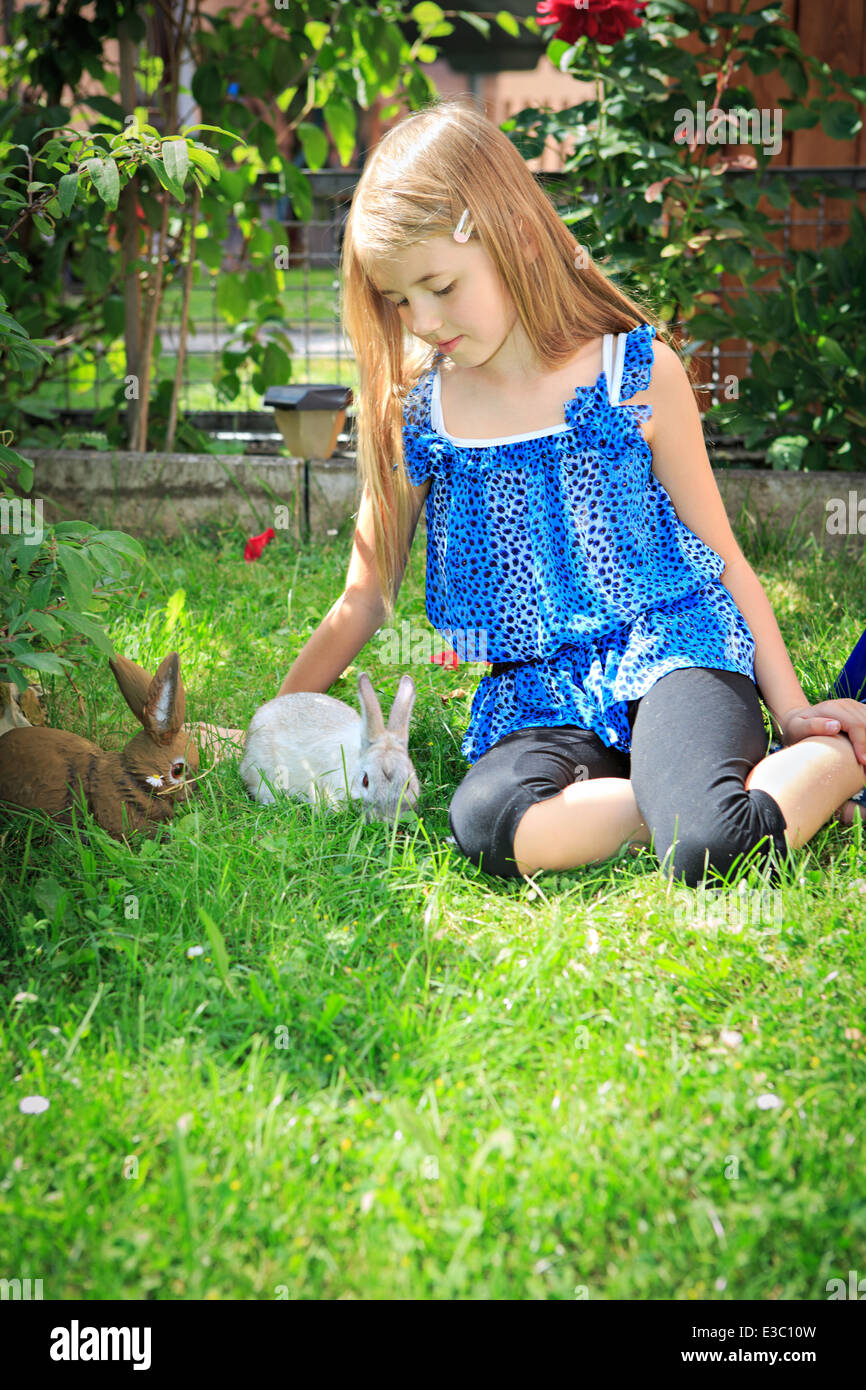 Teenage girl playing with a rabbit in the backyard Stock Photo - Alamy