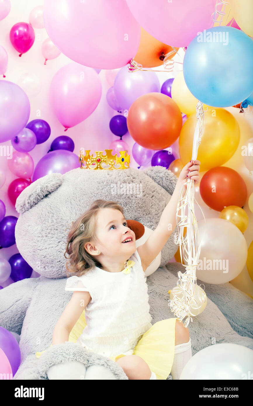 Cheerful little girl grabs bunch of balloons Stock Photo - Alamy