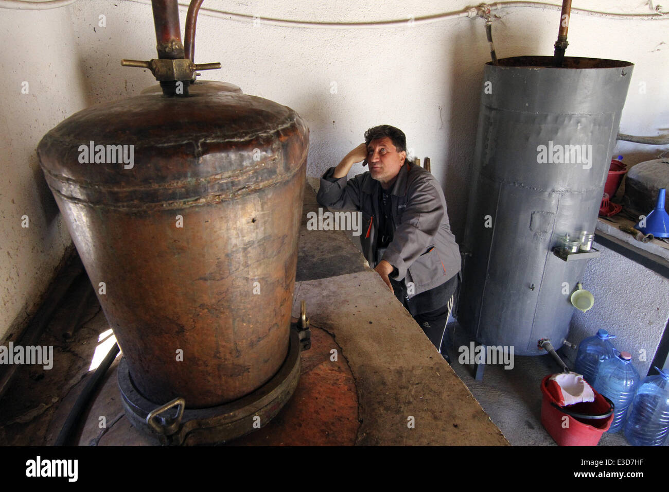 A Bulgarian man checks the alcoholic quality at a small home raki ...