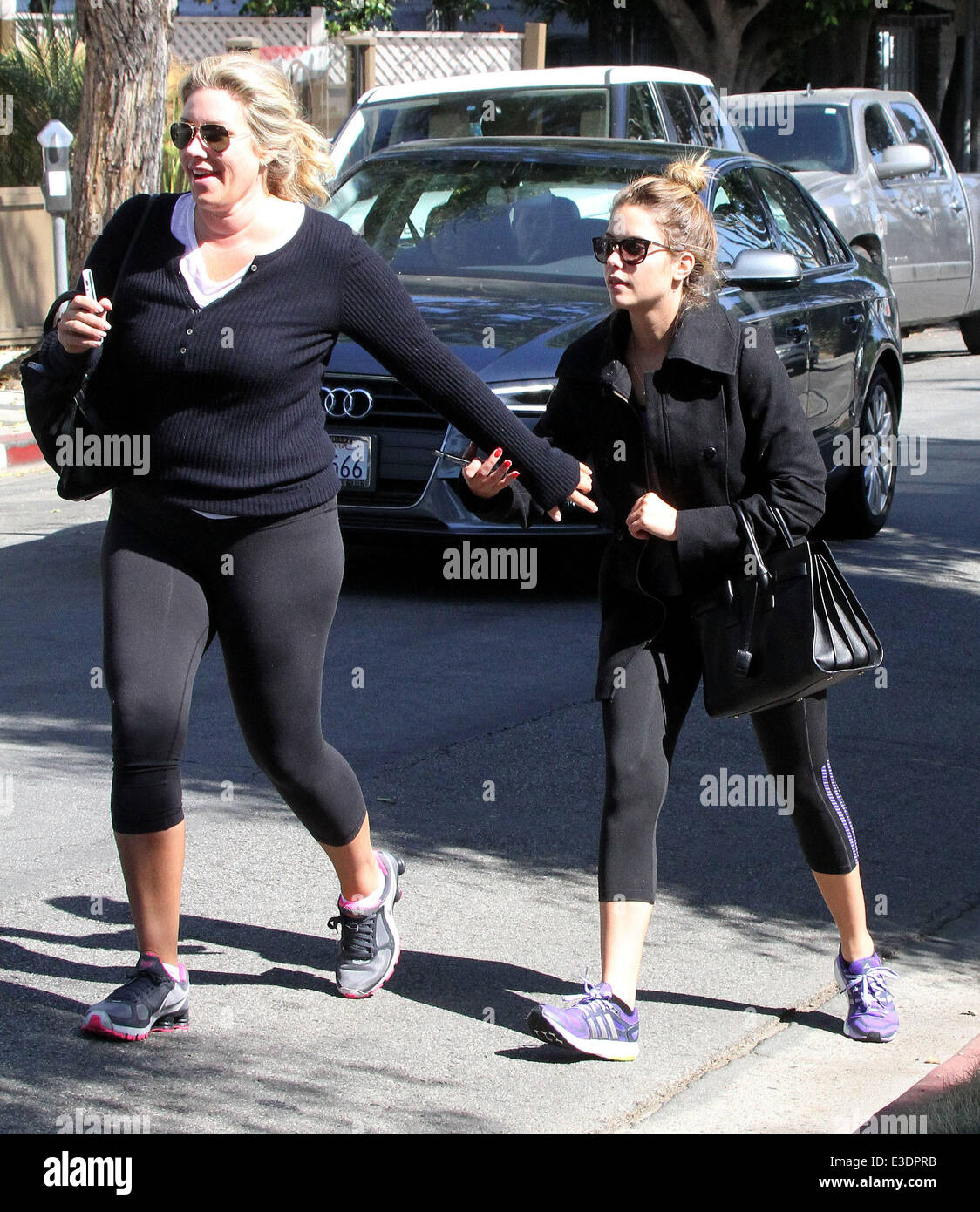 Ashley Benson, wearing a winter coat, arrives at a gym for a workout ...