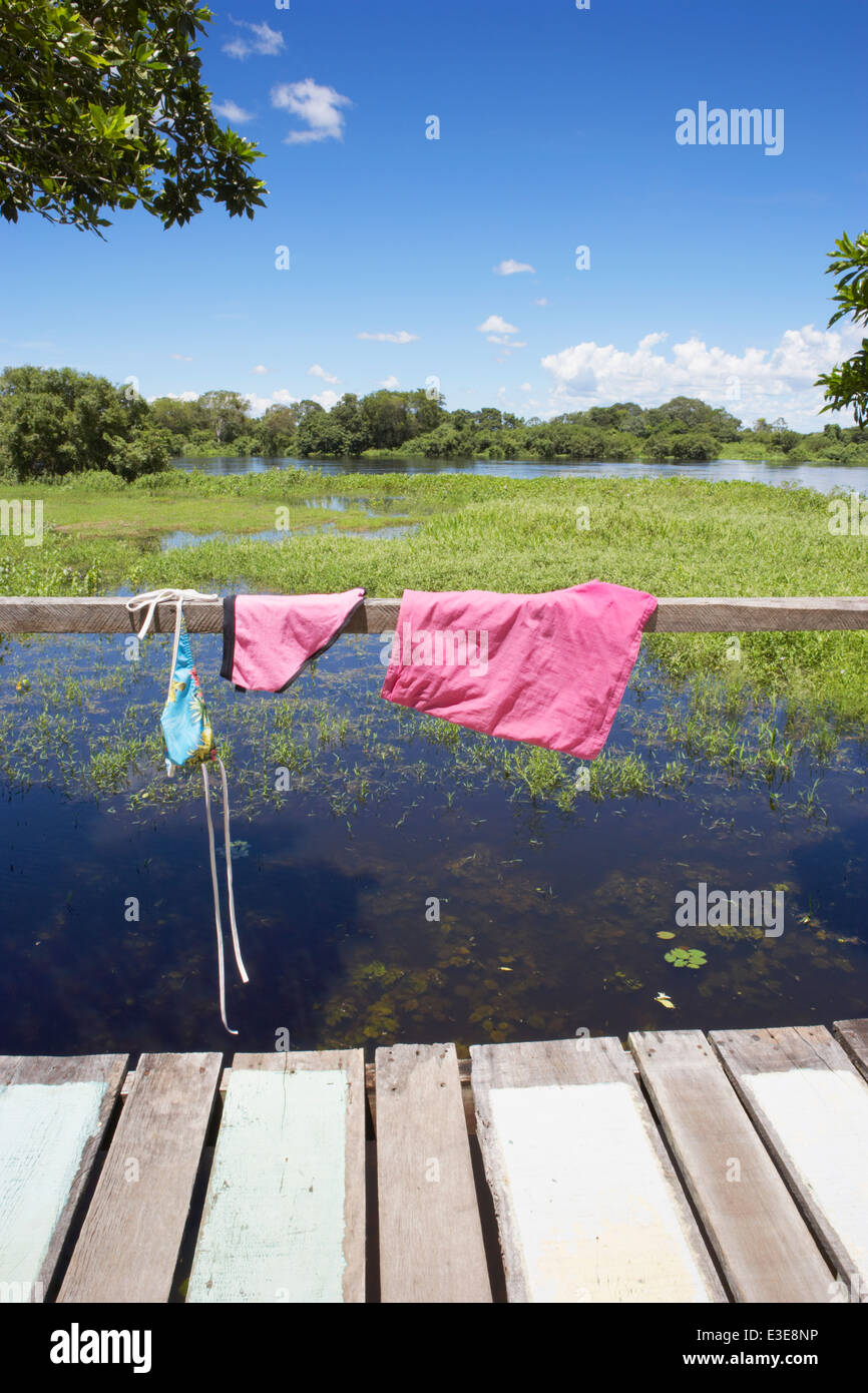 Swimming costume and shorts in sun, in front of wetlands and river ...