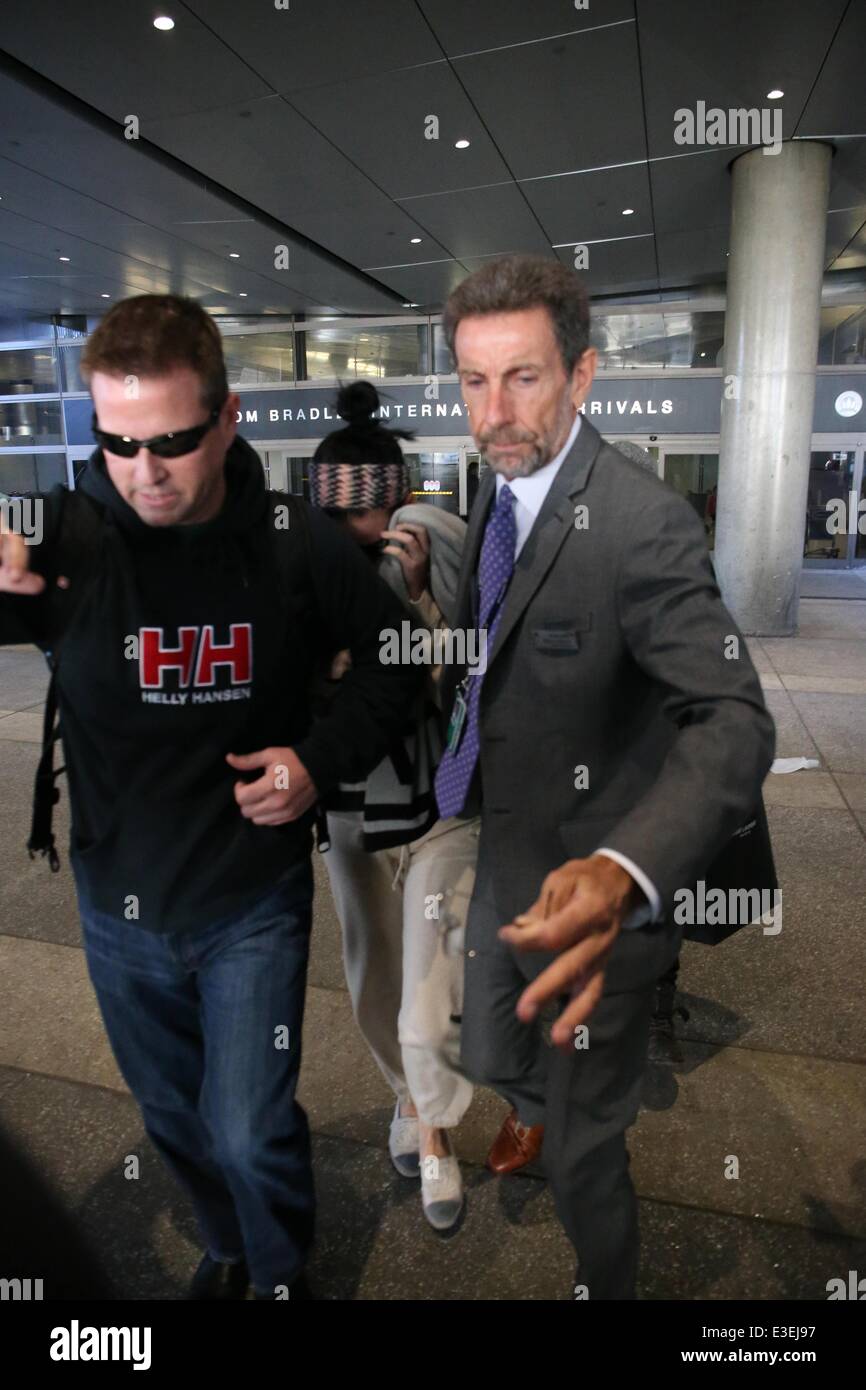 Katy Perry arrives at LAX hiding behind her bodyguard and an airline ...
