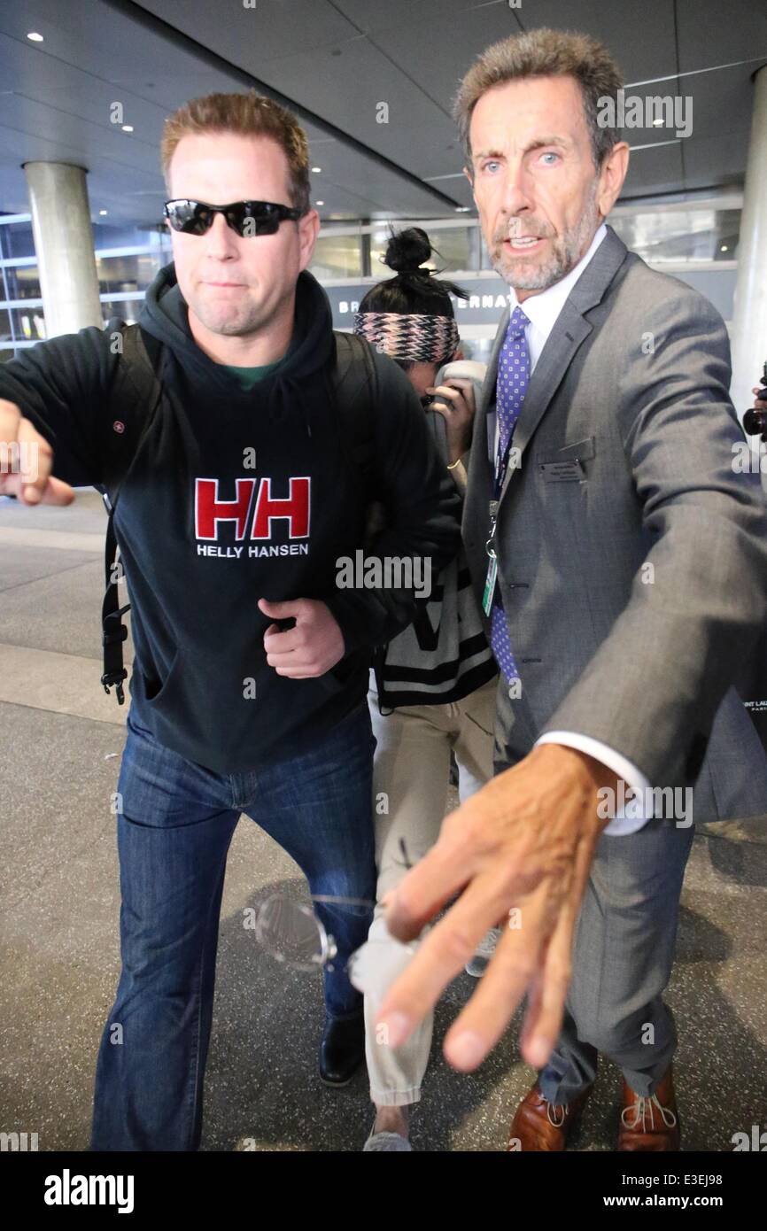 Katy Perry arrives at LAX hiding behind her bodyguard and an airline ...