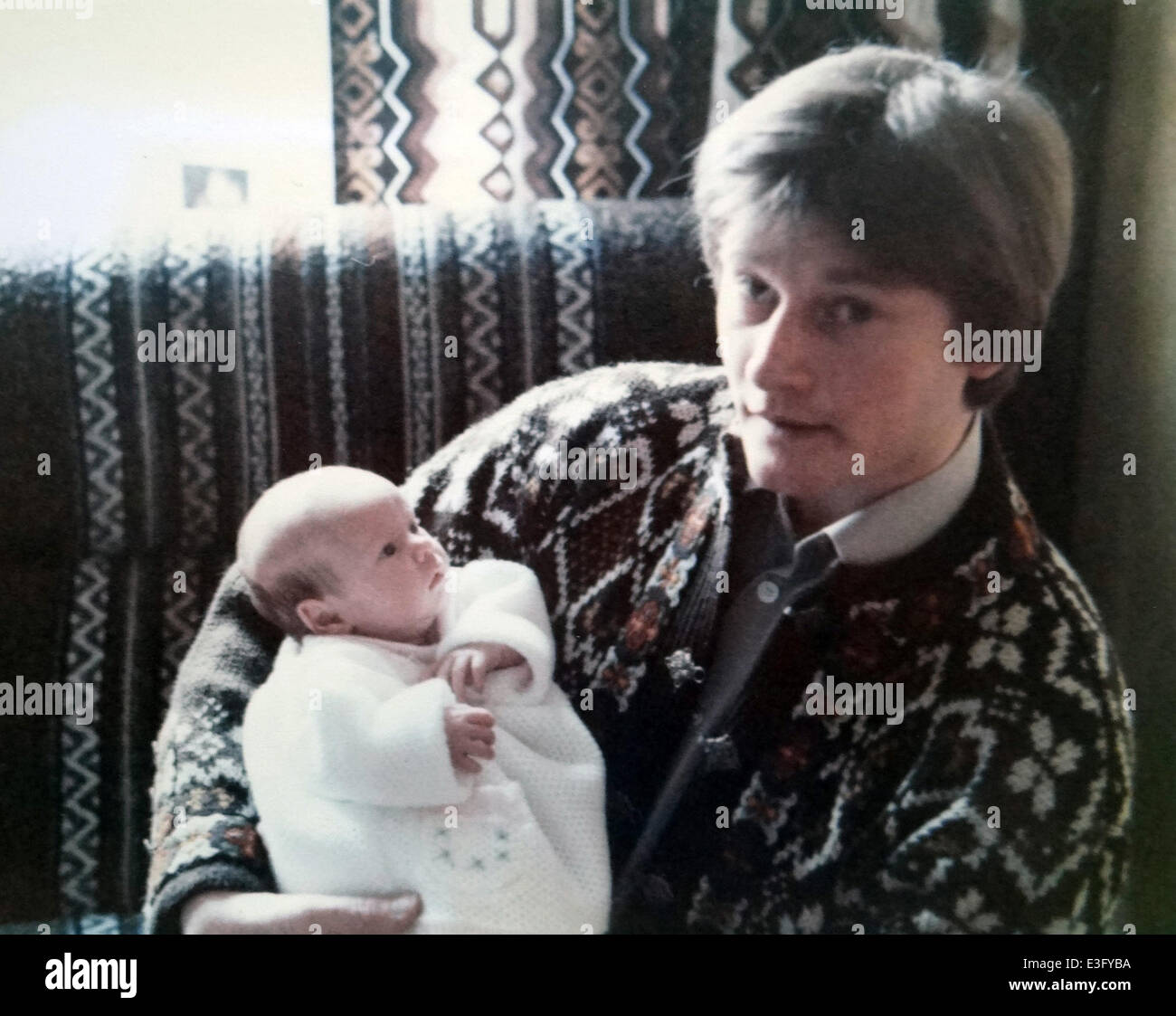 Alex Fleming wearing his favourite cardigan and holding his baby ...