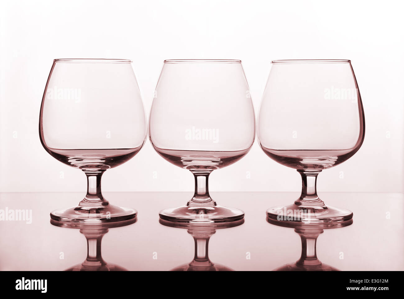 three empty wine glass on glass table Stock Photo - Alamy
