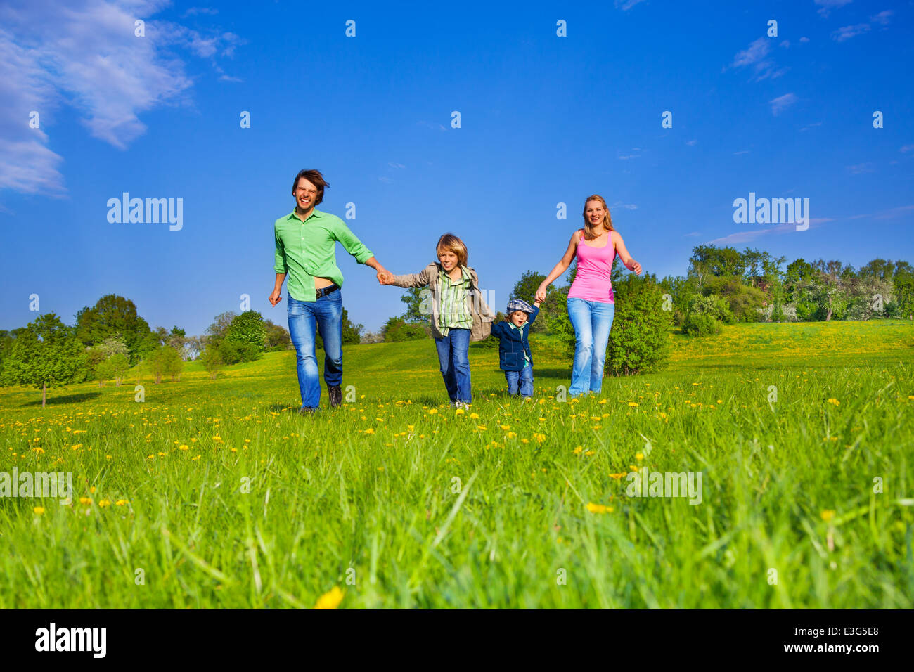 Happy parents walk with boys in park Stock Photo - Alamy