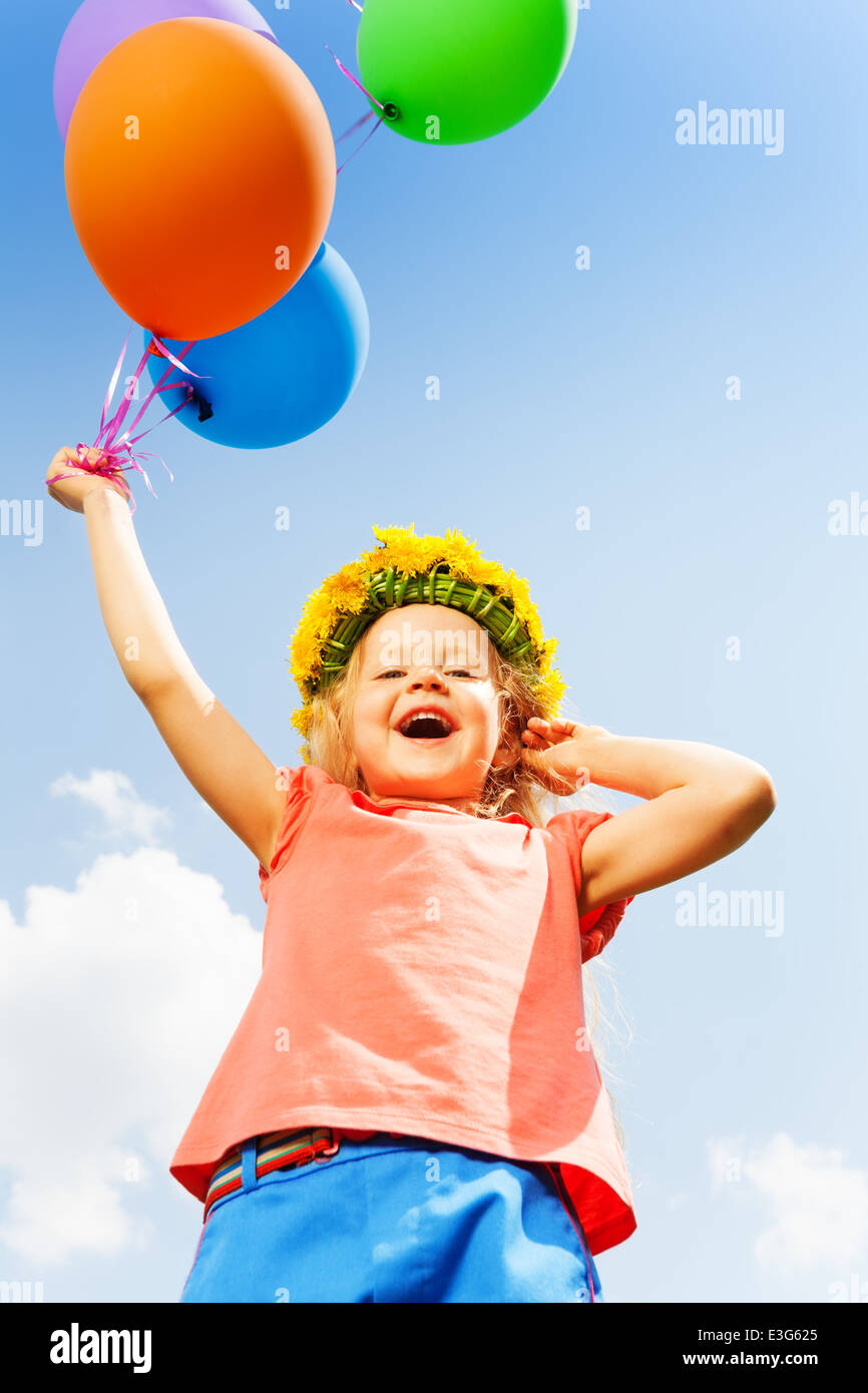 Positive girl with balloons wears flower circlet Stock Photo - Alamy