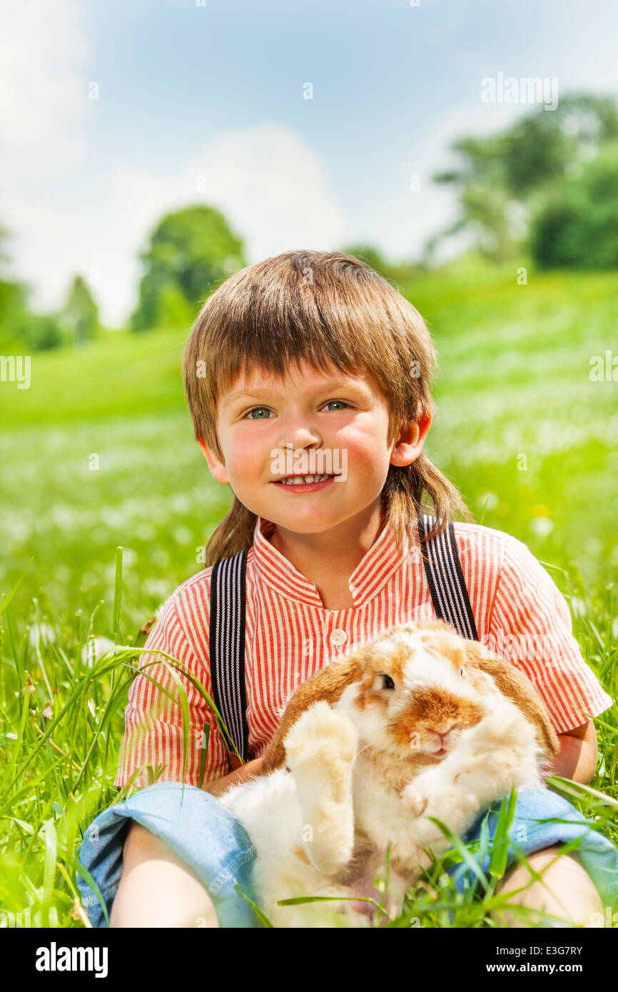 Small boy hugging rabbit in green field Stock Photo - Alamy