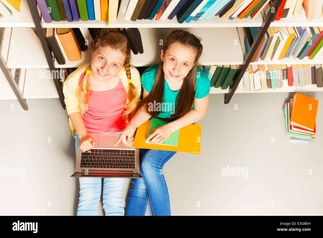 Two smiling girls portrait from above in library Stock Photo - Alamy