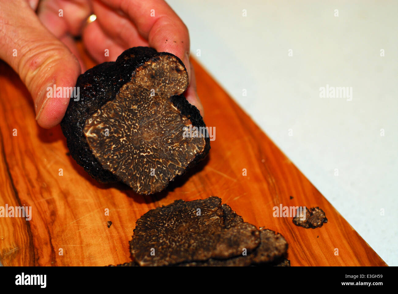 A person showing a large cut black truffle Stock Photo - Alamy