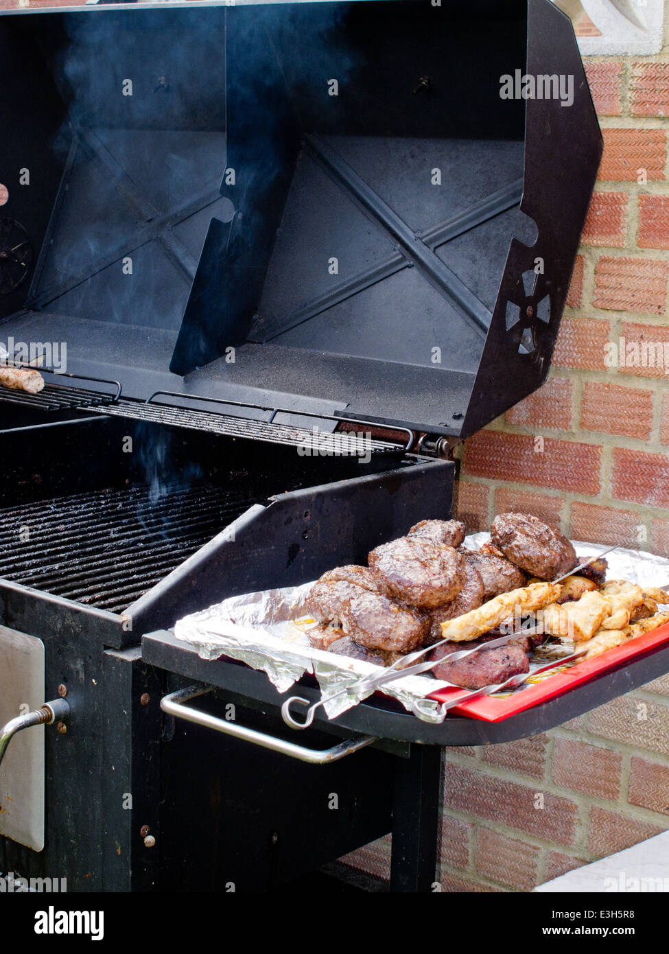 A BBQ with burgers and chicken by the side after being cooked Stock ...