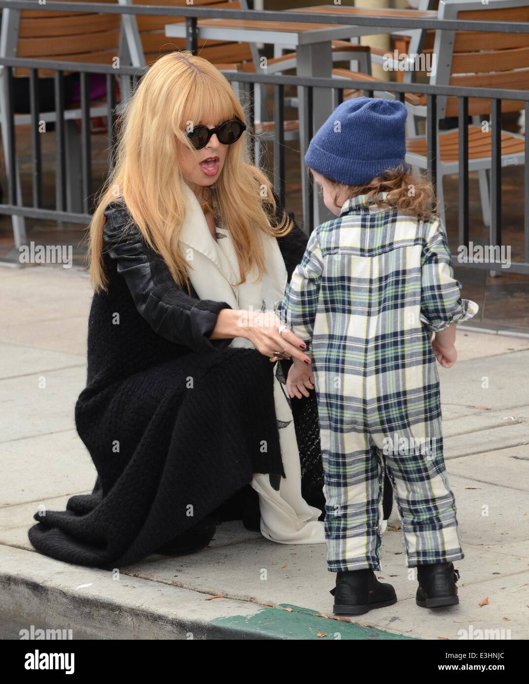 Rachel Zoe in mono, wearing a long knitted coat, black boots and long ...