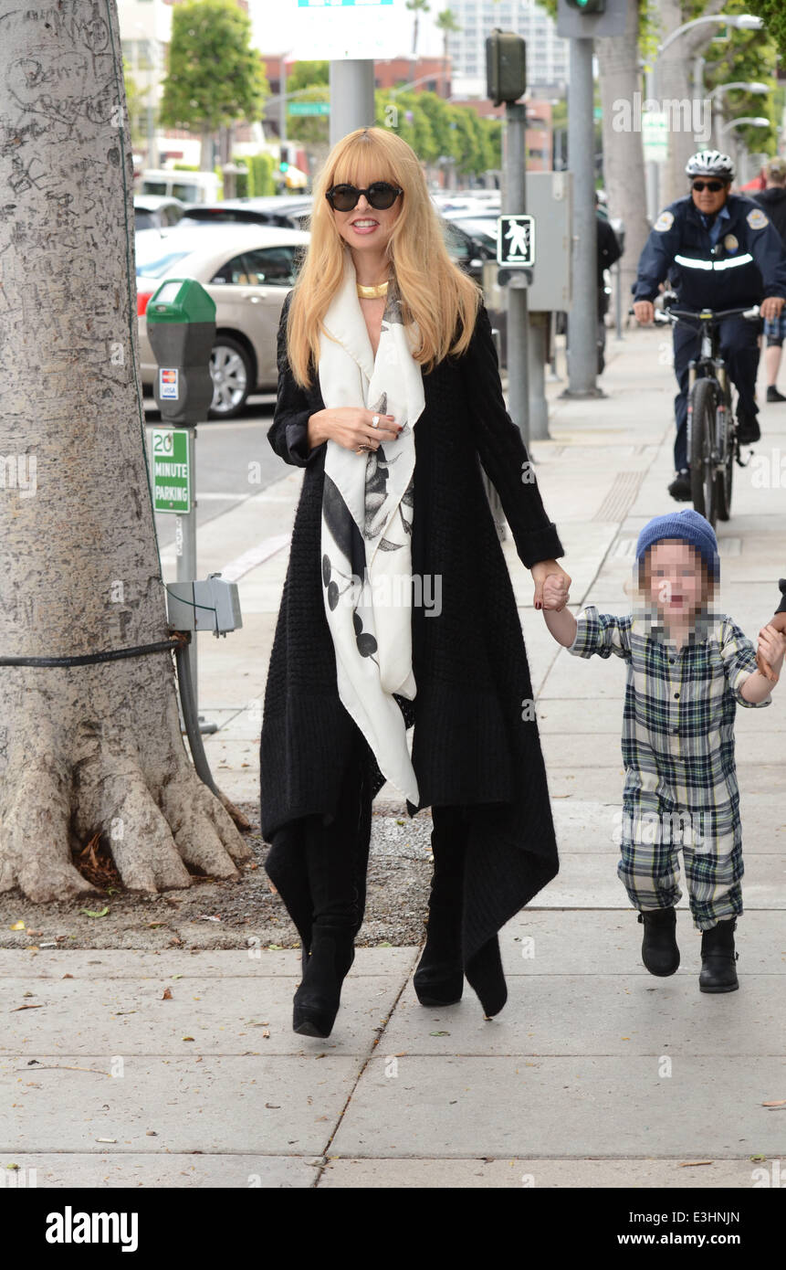 Rachel Zoe in mono, wearing a long knitted coat, black boots and long ...