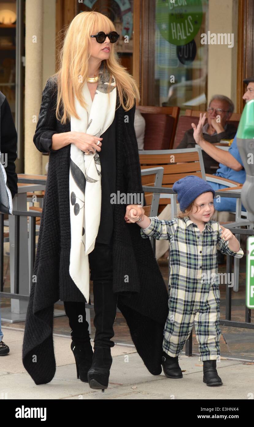 Rachel Zoe in mono, wearing a long knitted coat, black boots and long ...