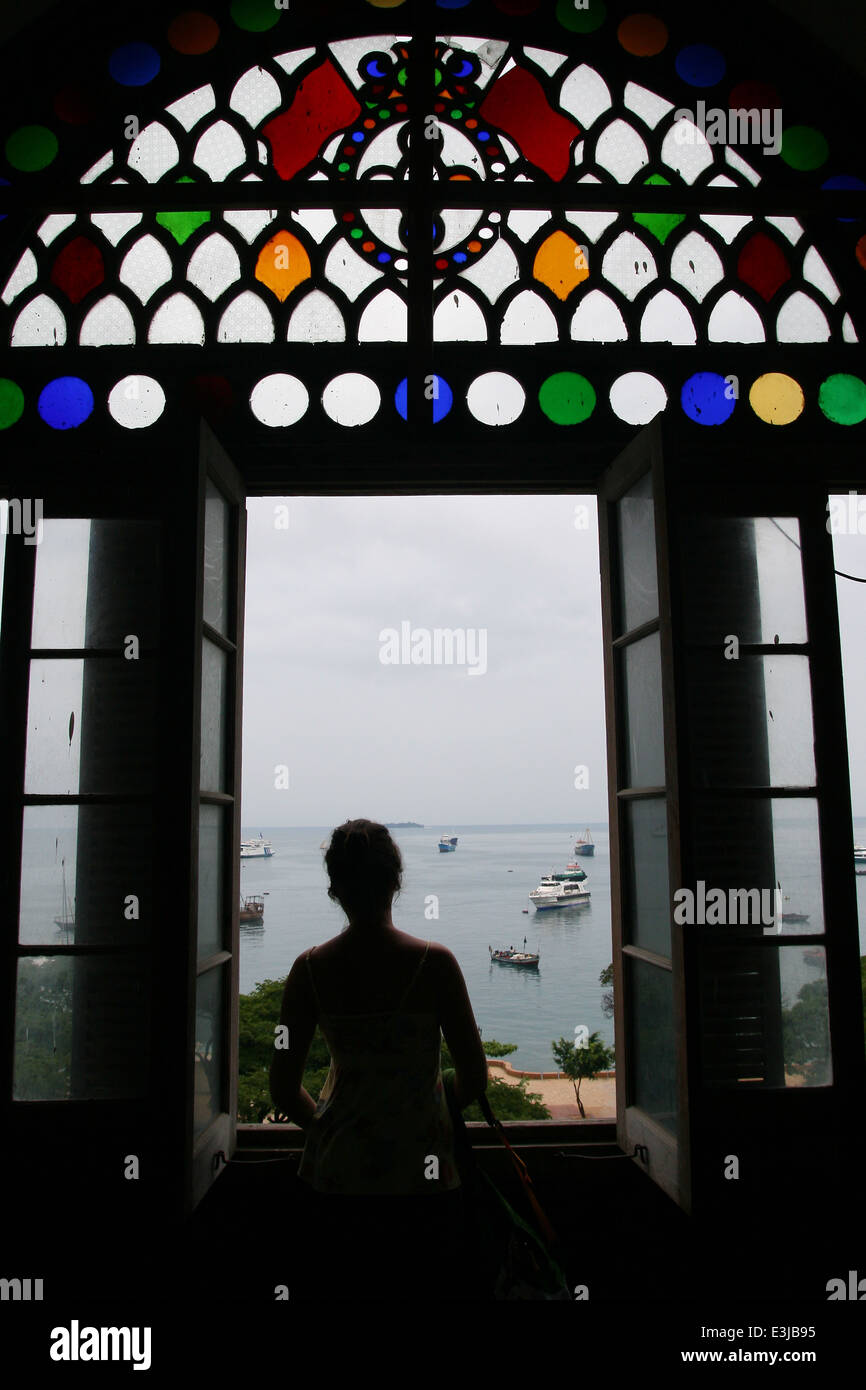 Woman looking through the window Stock Photo - Alamy