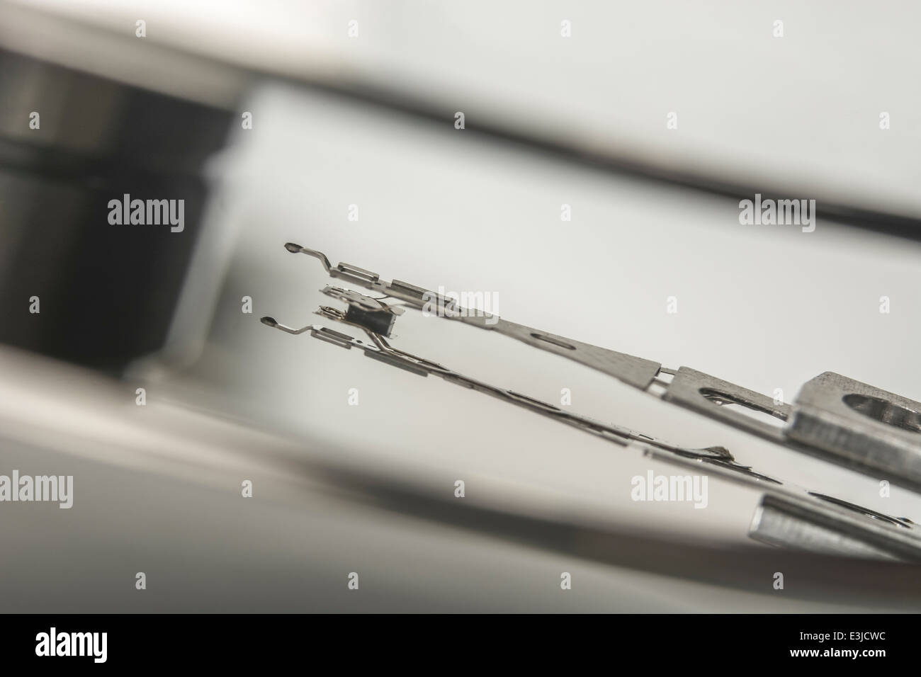 Macro photo of HDD read-write head and arm resting over disk platter ...