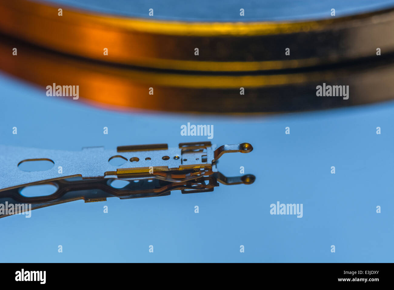 Macro photo of HDD read-write head and arm resting over disk platter ...