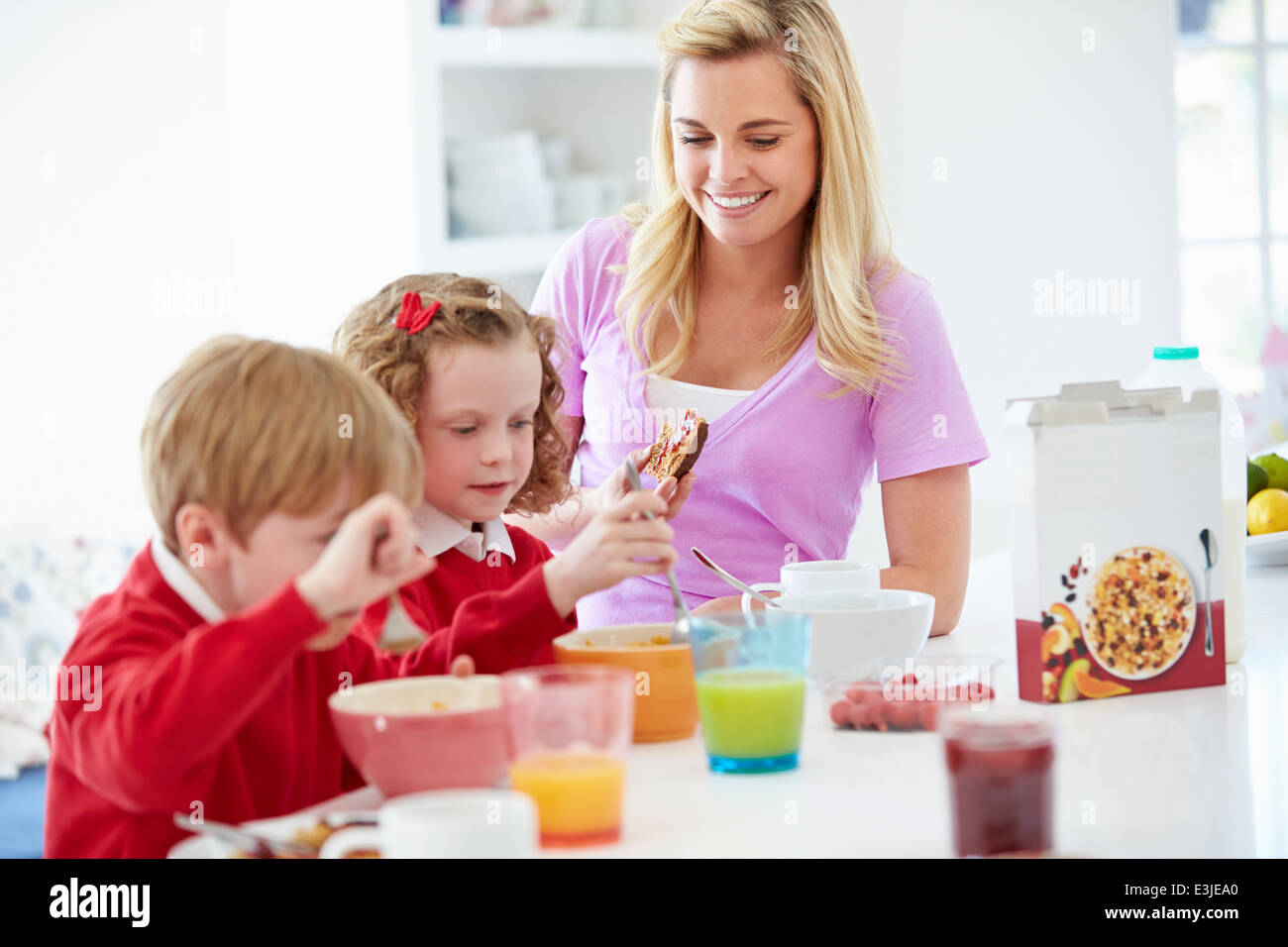 Mother And Children Having Breakfast In Kitchen Together Stock Photo ...