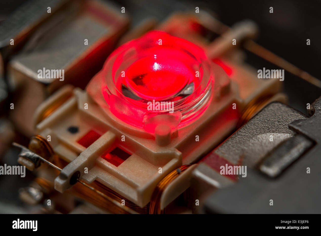 Macro-photo of CD-ROM laser assembly - lit internally with a red laser ...