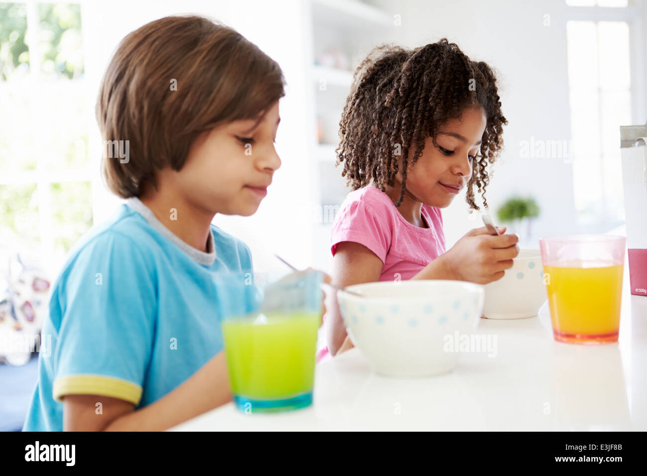 Two Children Having Breakfast In Kitchen Together Stock Photo - Alamy